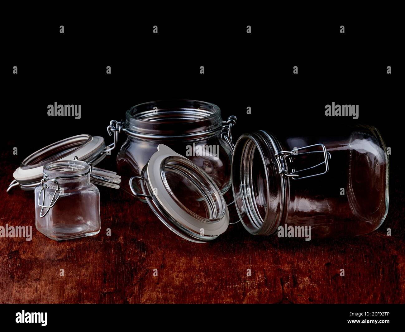 Empty glass jars with open lids are held in place with a metal wire ...