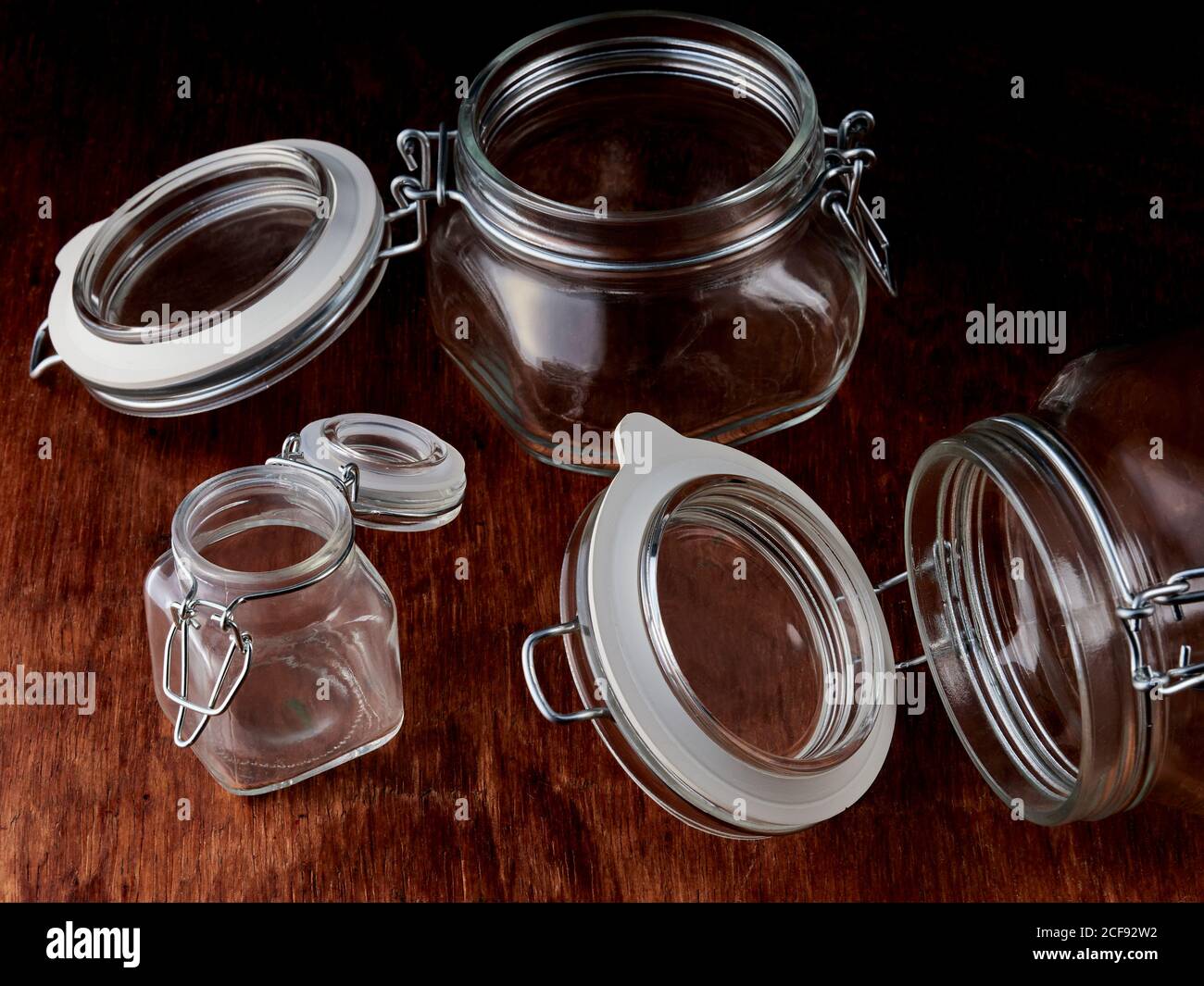 Empty glass jars with open lids are held in place with a metal wire ...