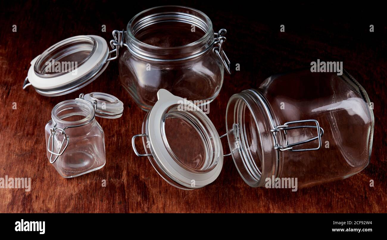 Empty glass jars with open lids are held in place with a metal wire ...