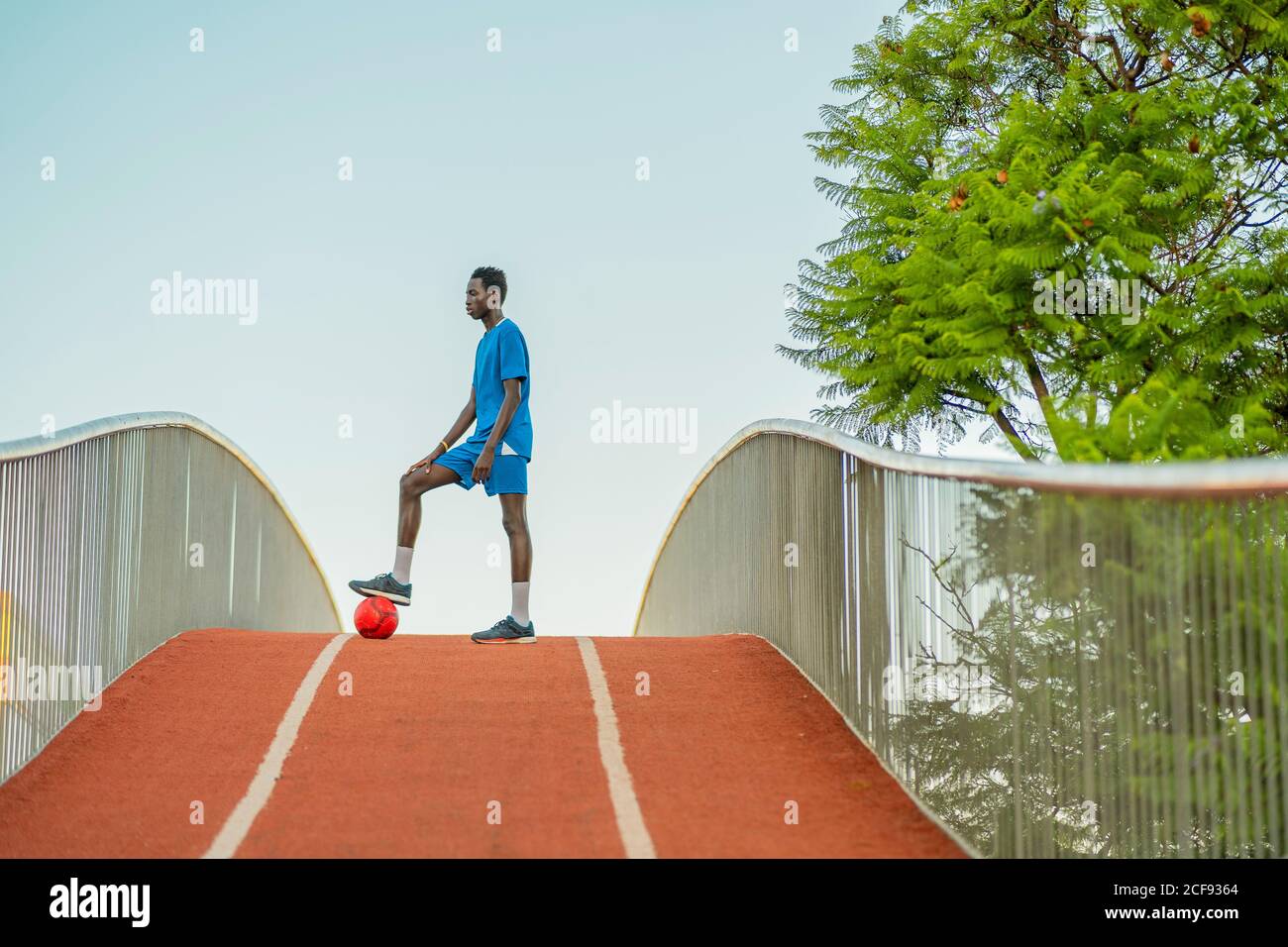 Ethnic football player standing on path Stock Photo - Alamy