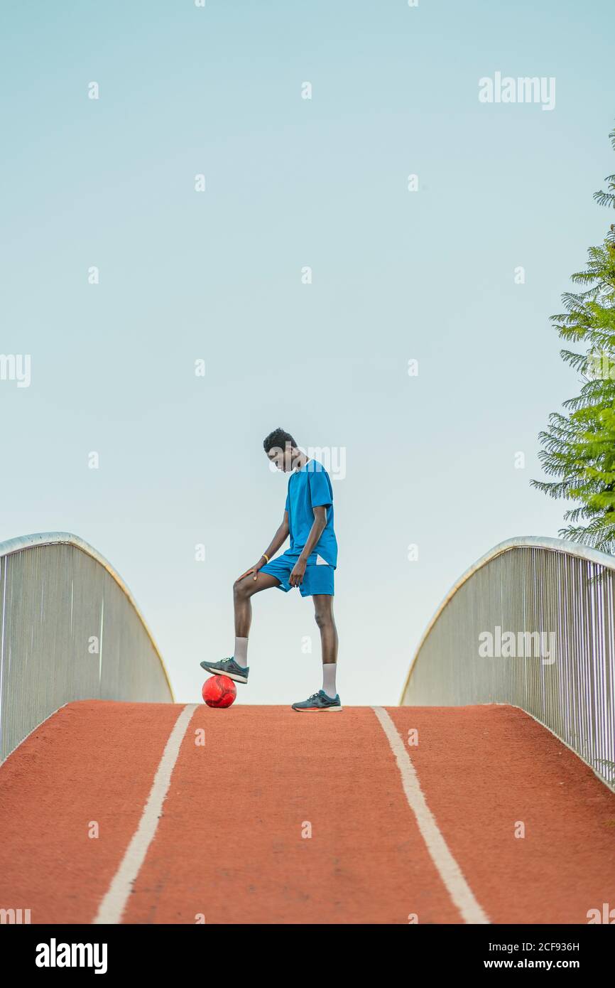 Ethnic football player standing on path Stock Photo - Alamy
