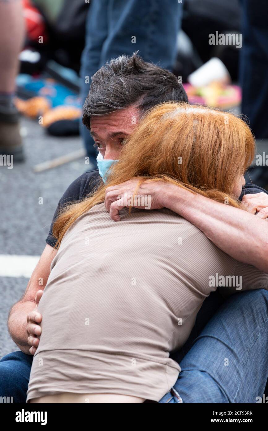 Two protesters embrace while blocking a road during Extinction ...