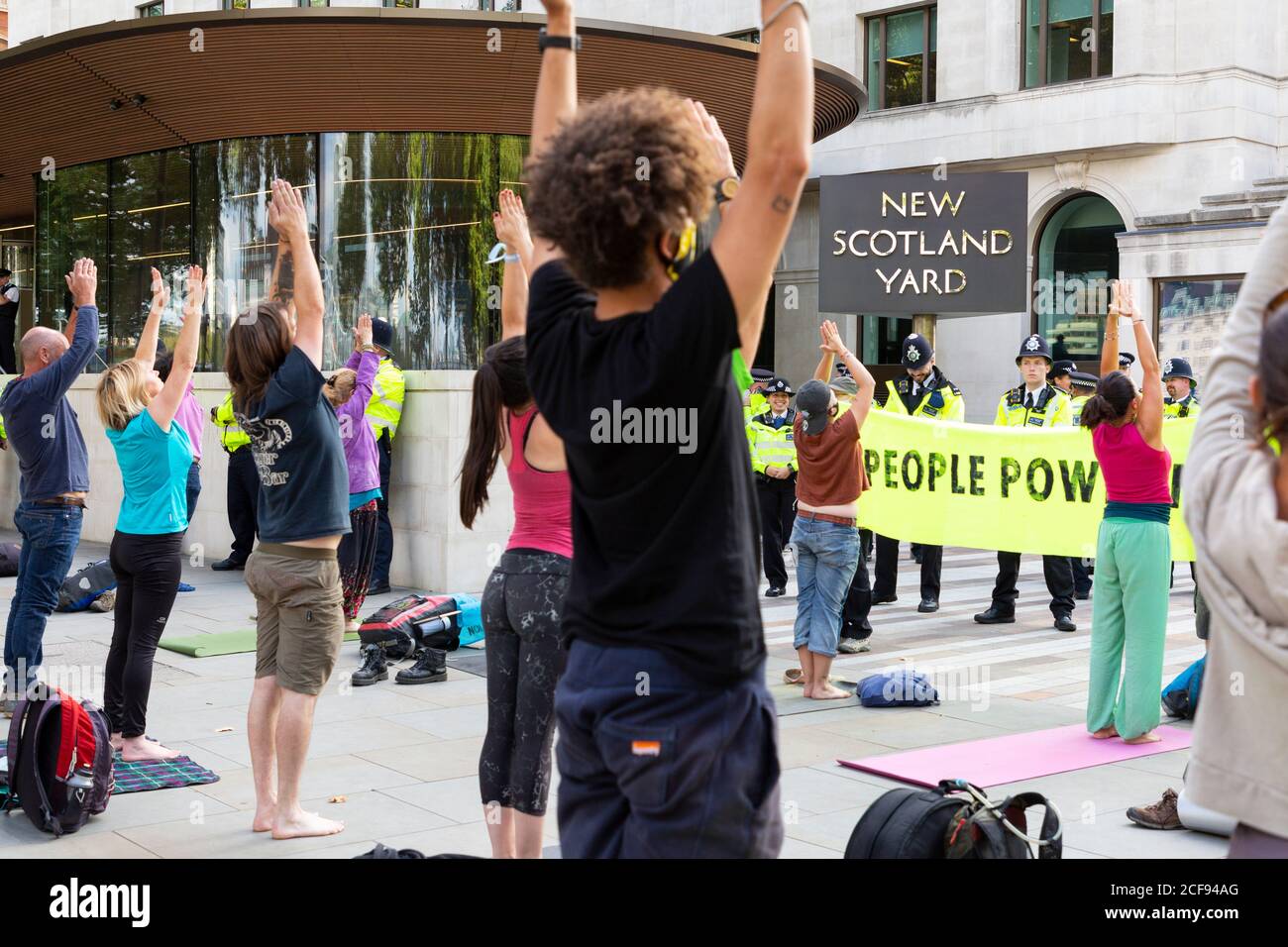 Protesters strike yoga poses outside New Scotland Yard during ...