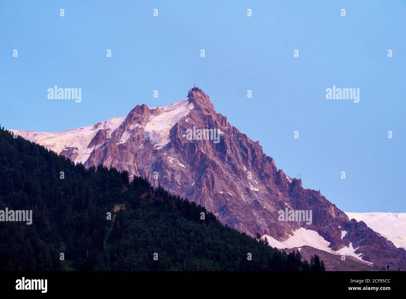 White sharp mountain peaks in snow raising up to cloudy sky Stock Photo ...