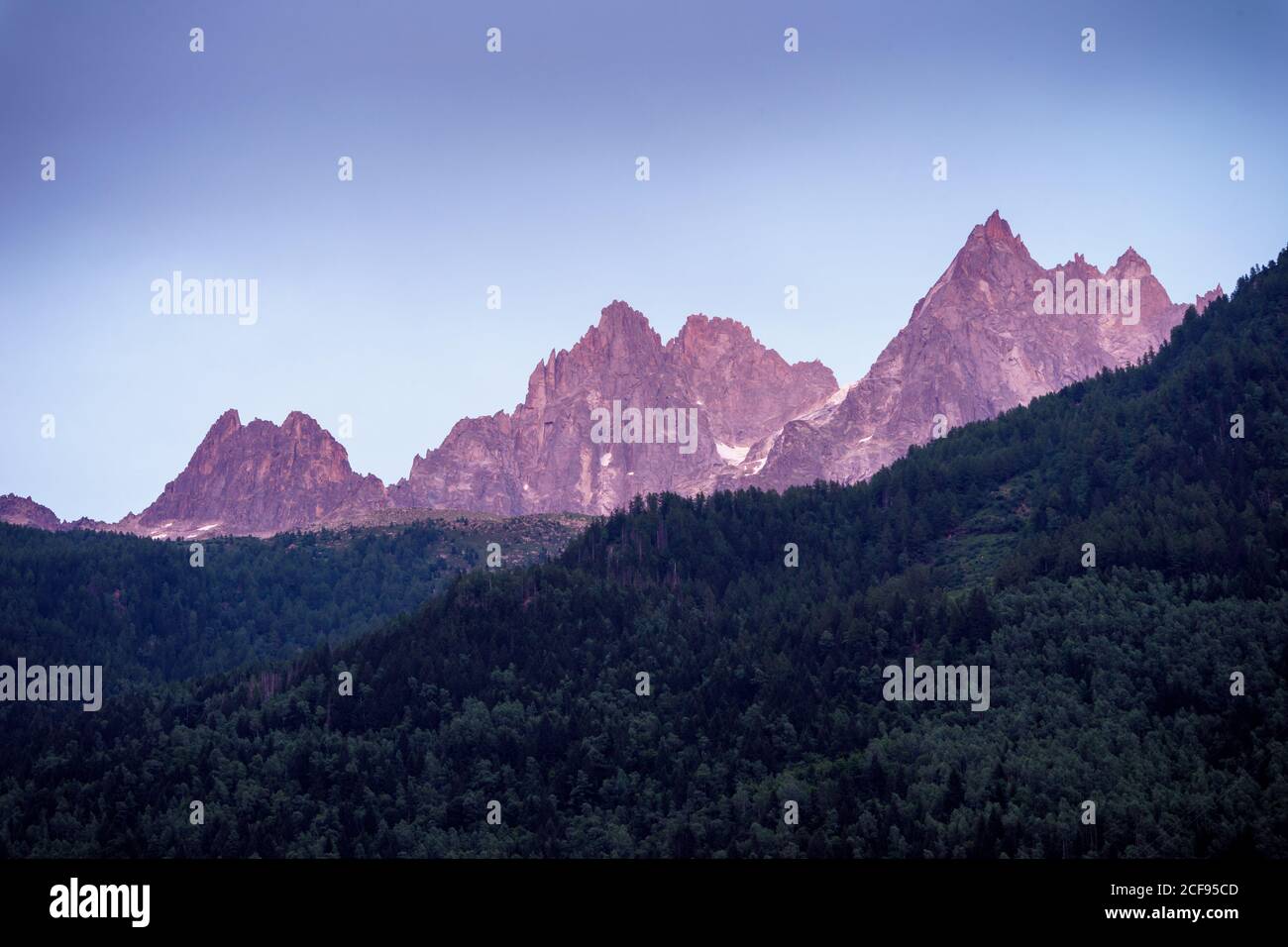 White sharp mountain peaks in snow raising up to cloudy sky Stock Photo ...