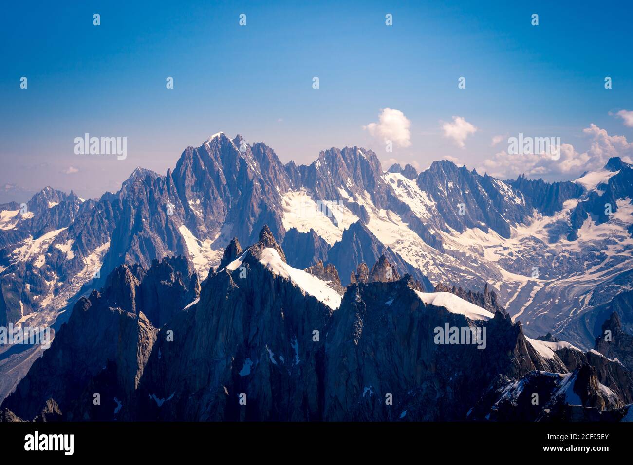 White sharp mountain peaks in snow raising up to cloudy sky Stock Photo ...