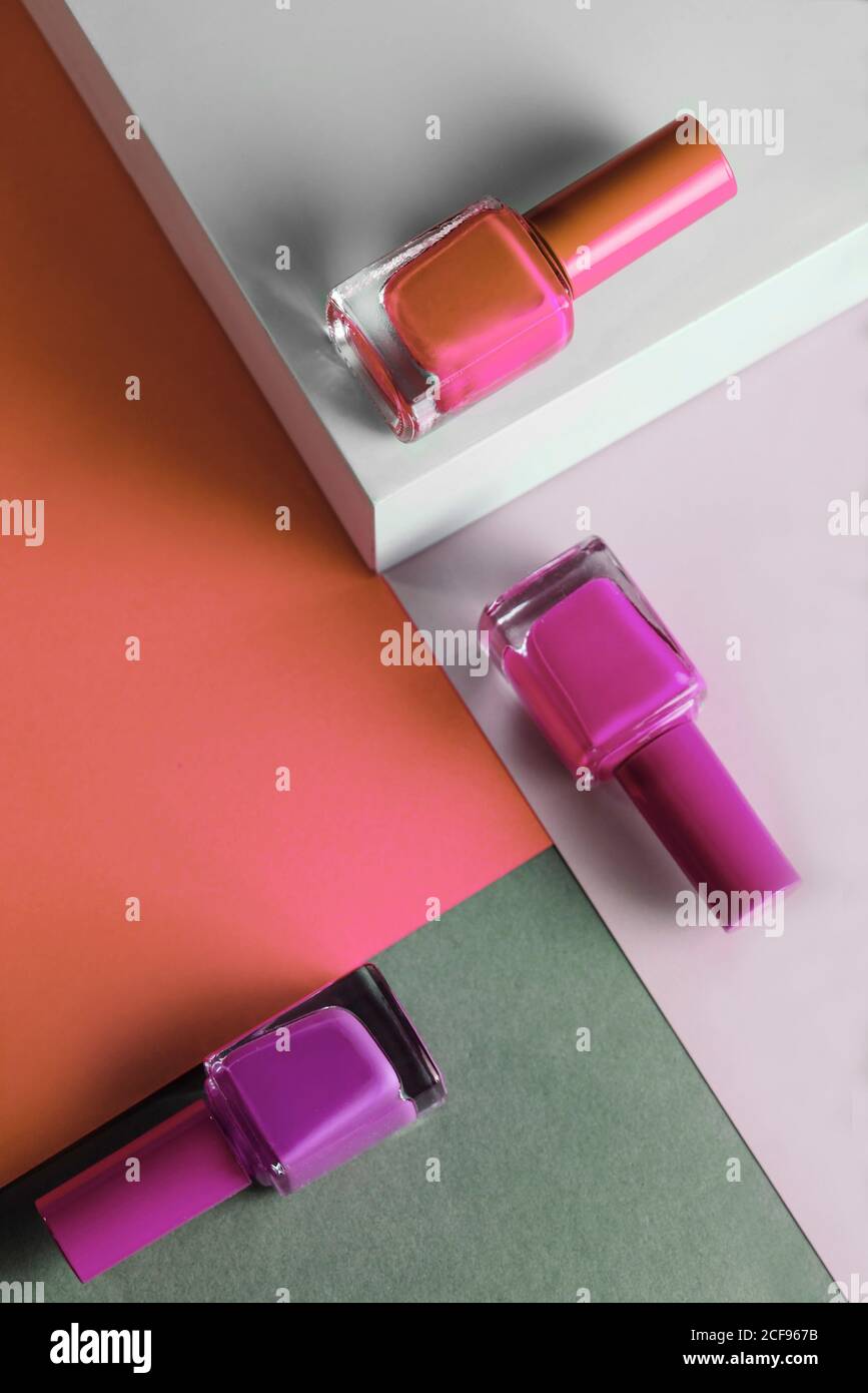 Multi-colored nail polish on pastel colors geometric pattern background ...