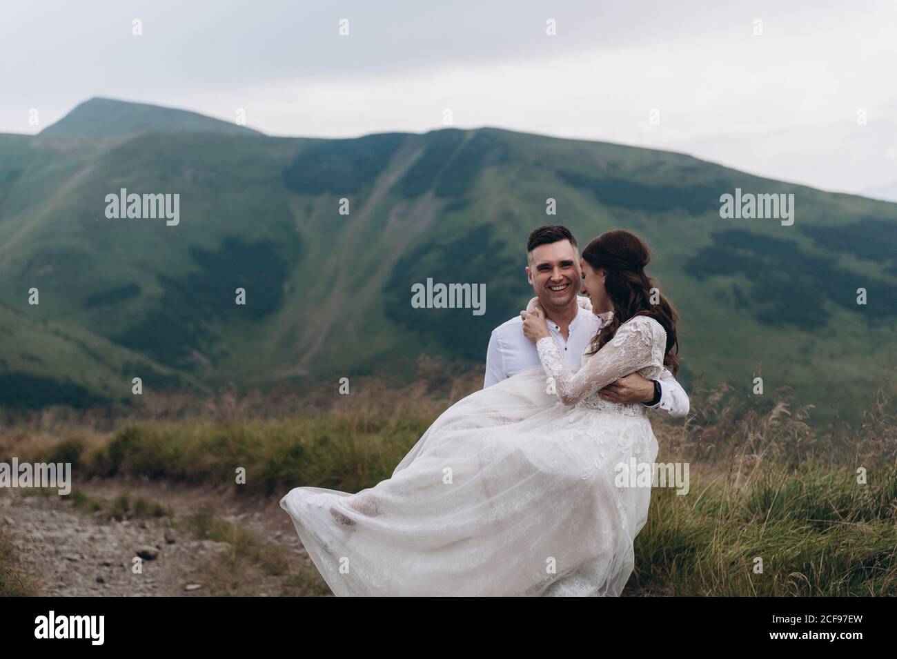 Handsome groom carrying bride hi-res stock photography and images - Alamy