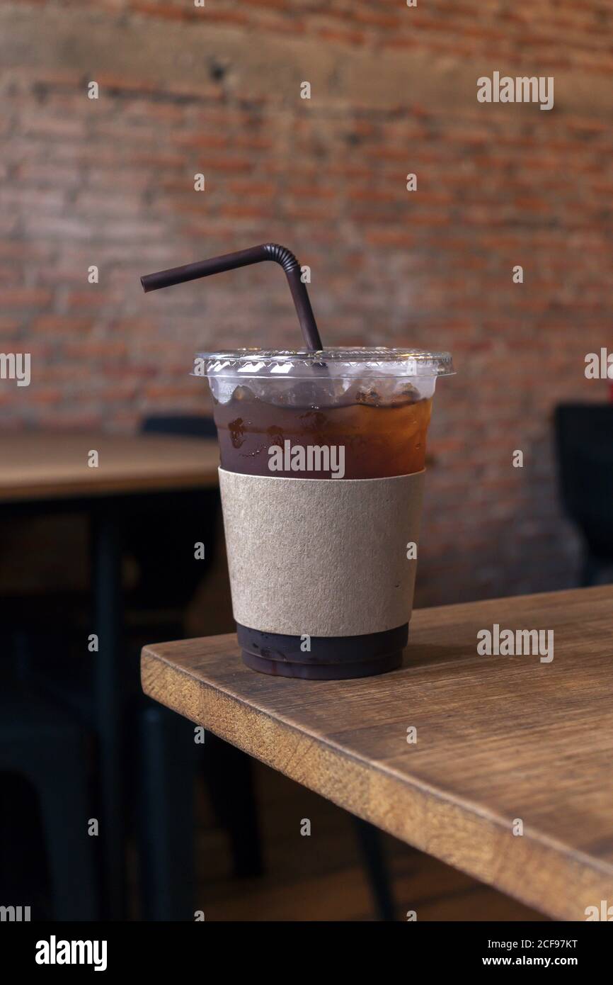 Vertical shot of a plastic cup of iced black coffee at a cafe Stock ...