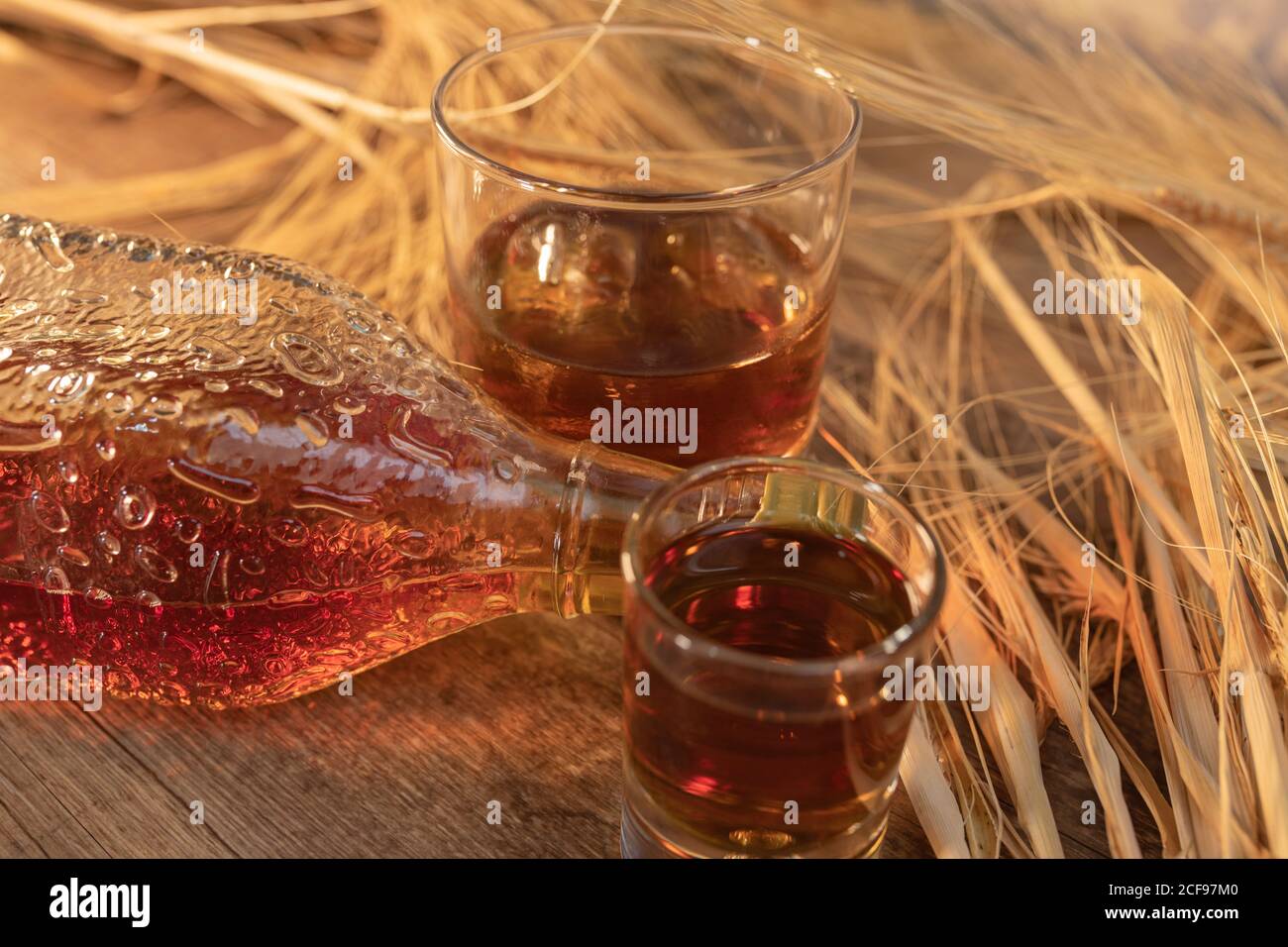 Bottle with beverage and shots on table Stock Photo - Alamy