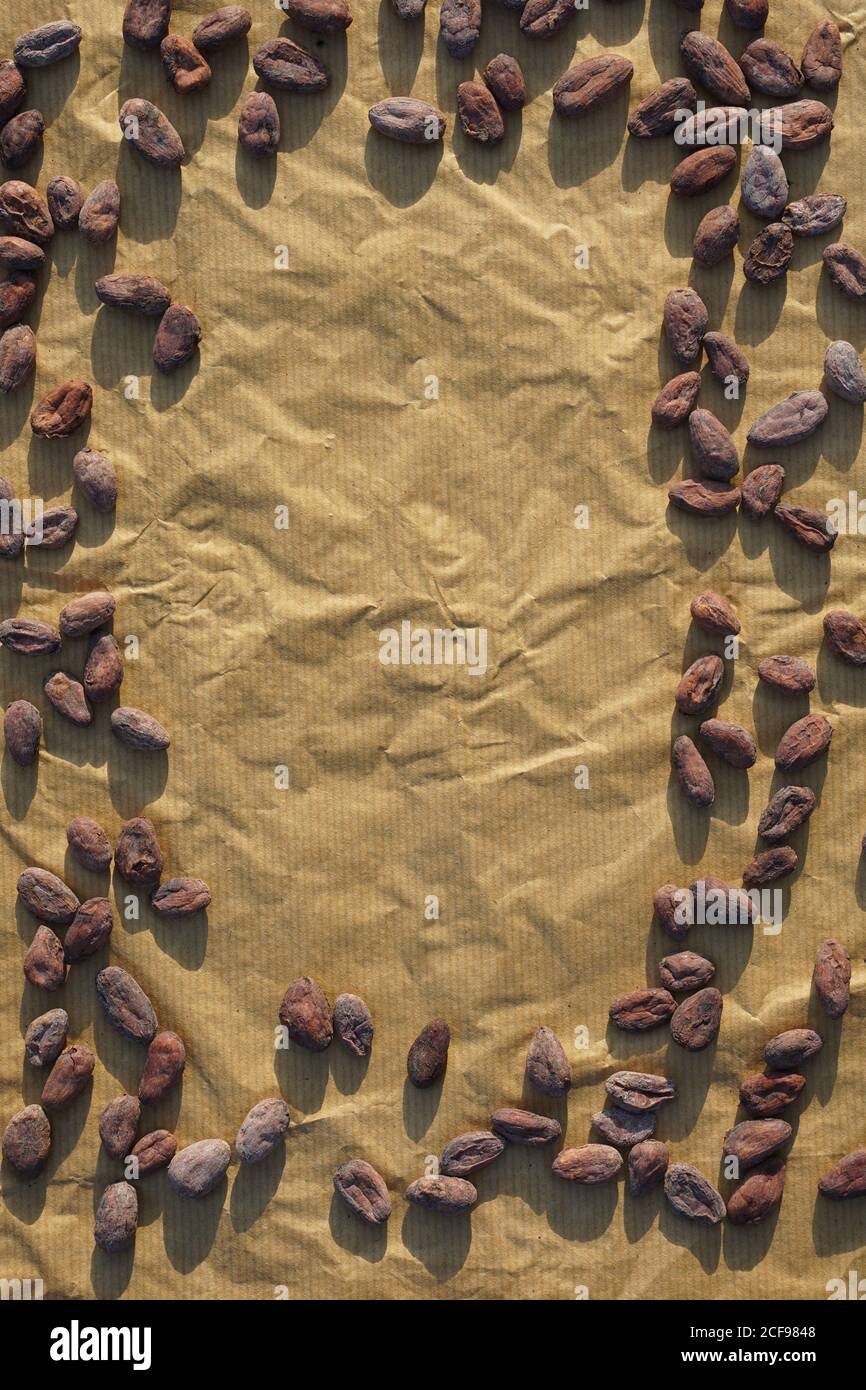 Cocoa flat lay concept with raw cocoa beans on craft paper background ...