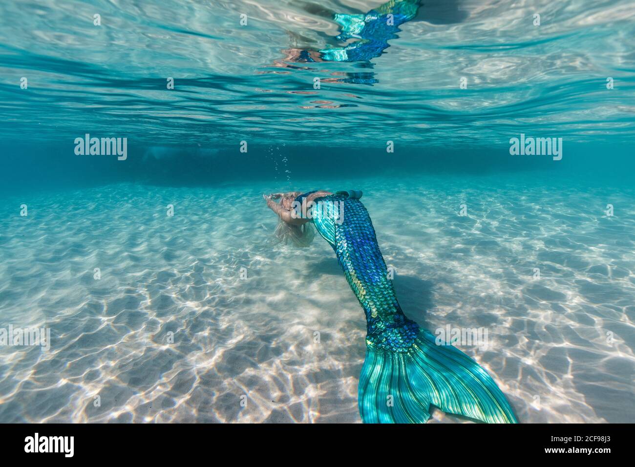 Beautiful carefree young mermaid with blue fishtail swimming underwater ...