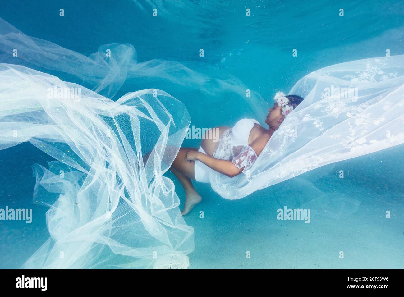 Beautiful pregnant Woman in floral wreath and long translucent white ...