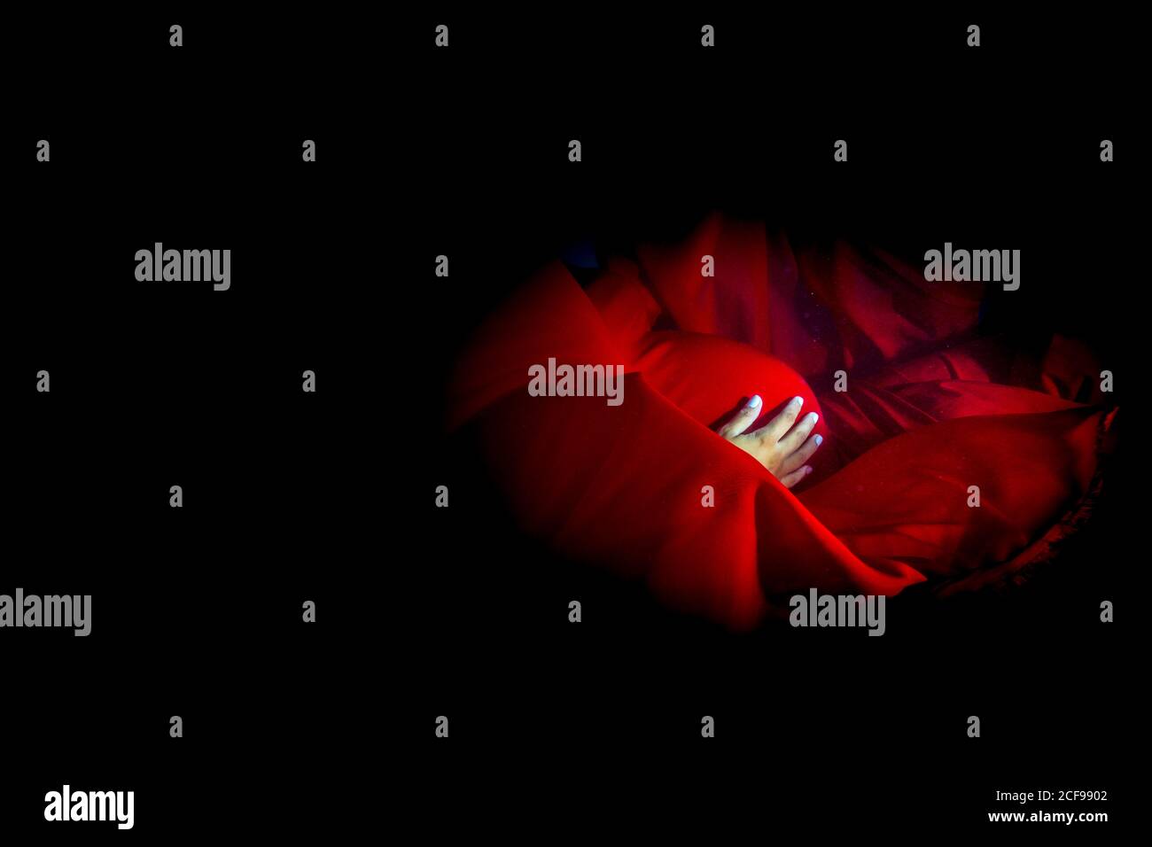 Beautiful pregnant Woman in red dress floating underwater with hands on ...