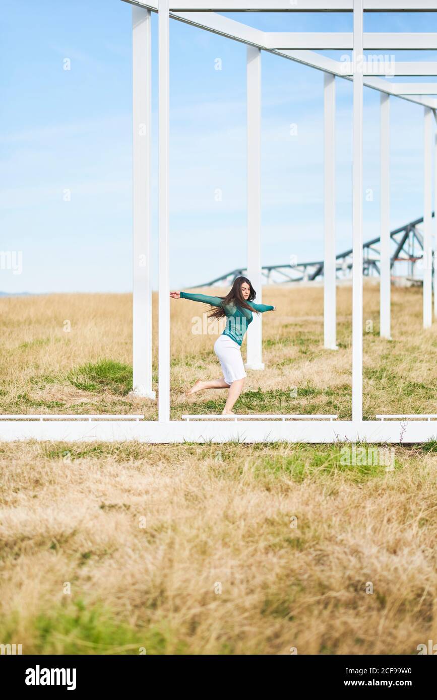 Young modern female dancing near contemporary geometrical construction ...