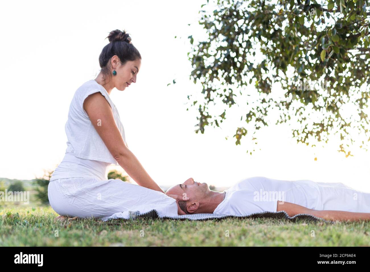calm couple meditating while man lying on mat with eyes closed and ...