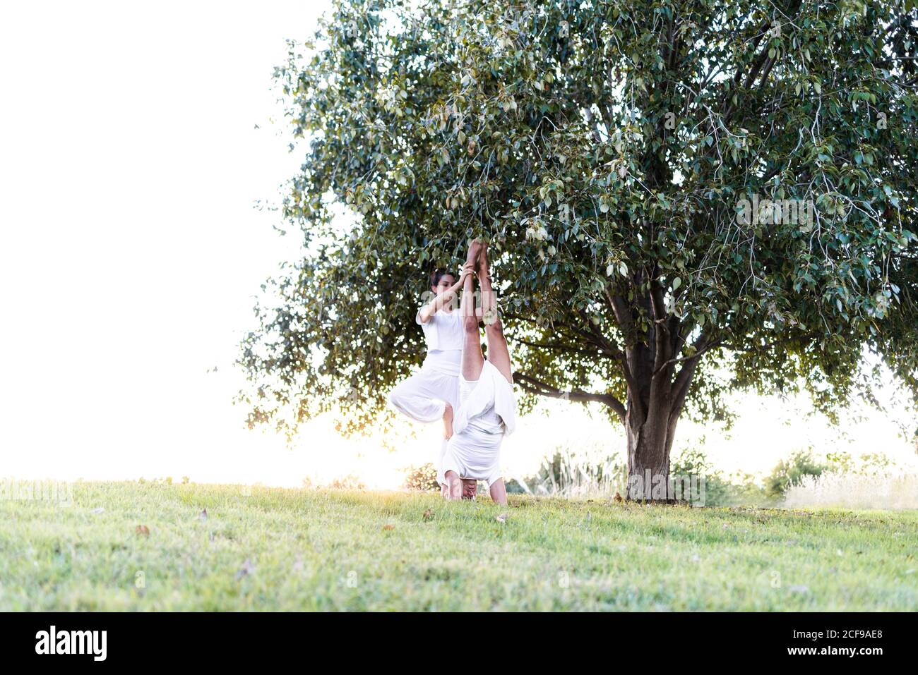 Side view of relaxed couple in yoga position raising legs up and ...