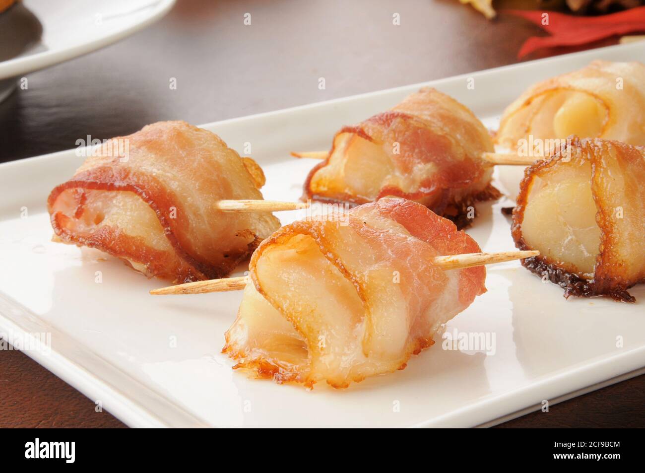 Delicious canapes of scallops wrapped in bacon Stock Photo - Alamy
