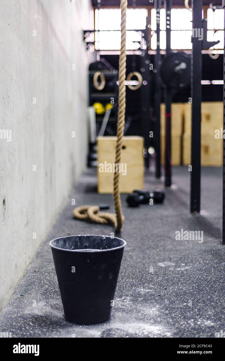Rope and bucket with chalk powder near wall in gym on blurred ...