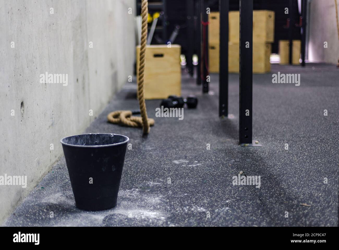 Rope and bucket with chalk powder near wall in gym on blurred ...