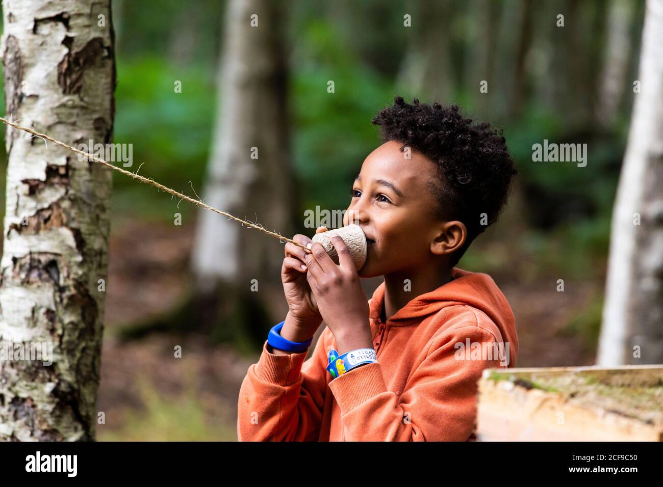 Boy talking on a string phone at art workshop at We Are Not a Festival ...