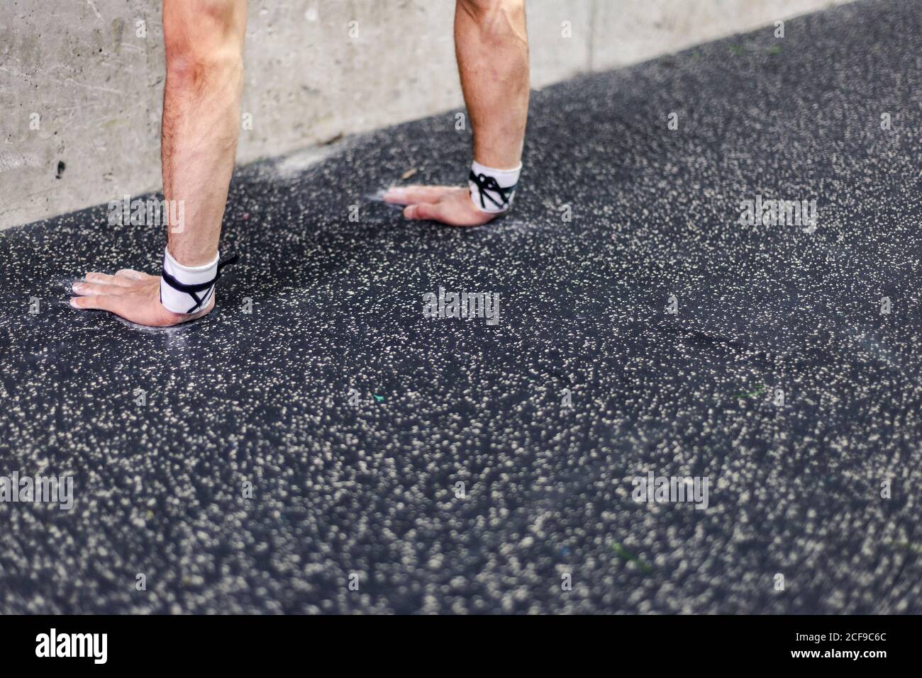 Crop hands of young male doing handstand near grey wall in gym Stock ...