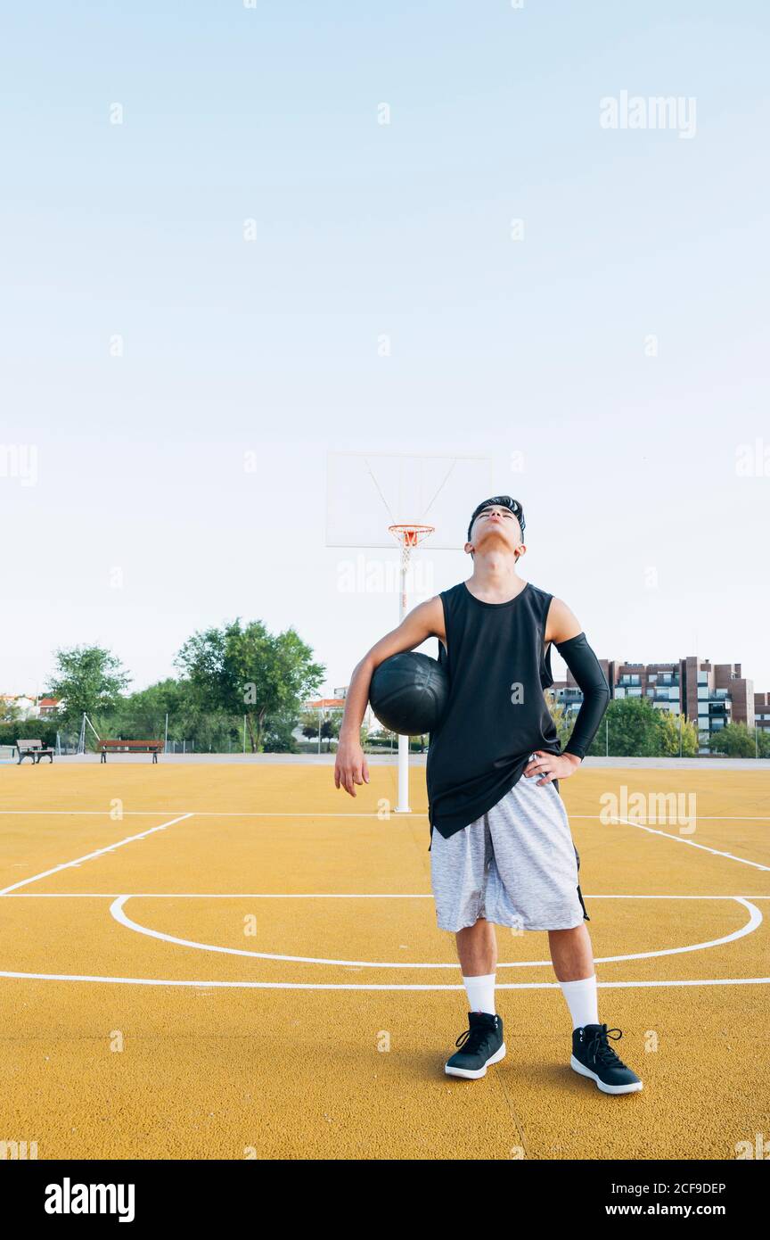 Young man playing on yellow basketball court outdoor Stock Photo - Alamy