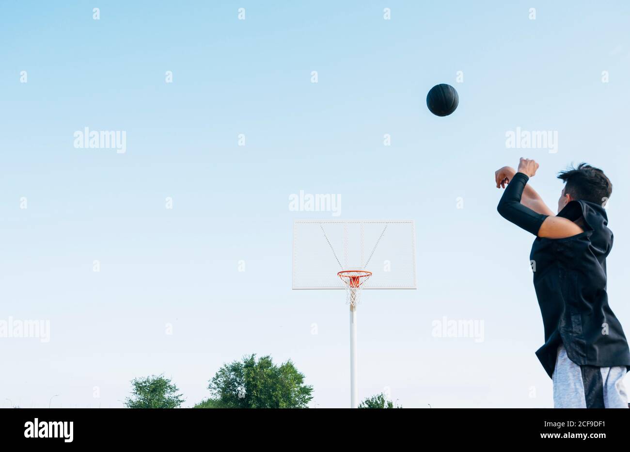 Young man playing on yellow basketball court outdoor Stock Photo - Alamy