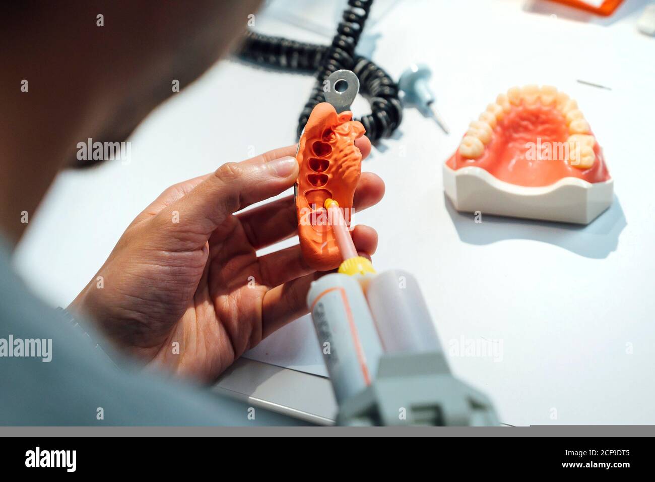 From above back view of crop male orthodontist using professional ...