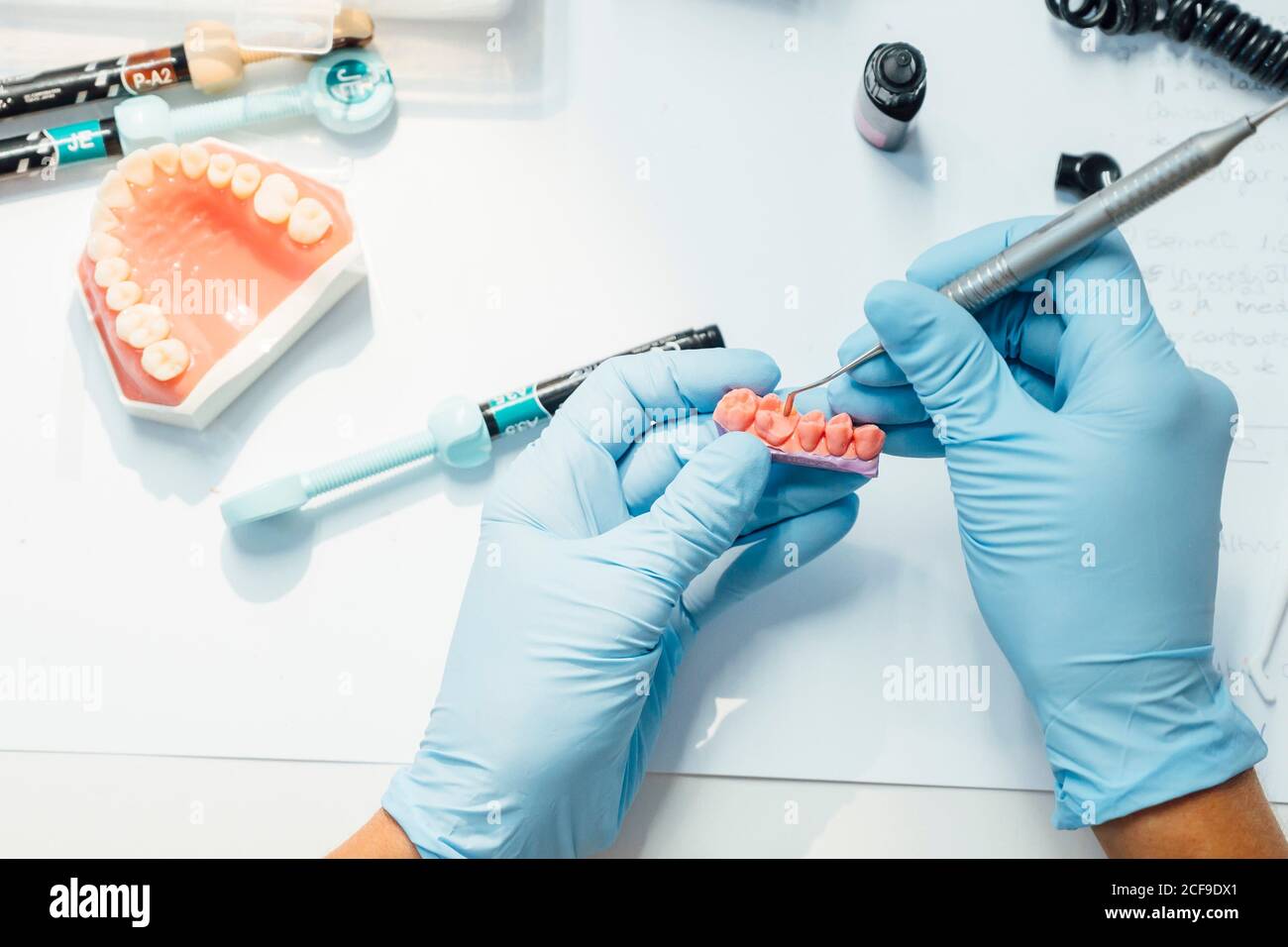 From above of crop student with artificial dental model and bur ...