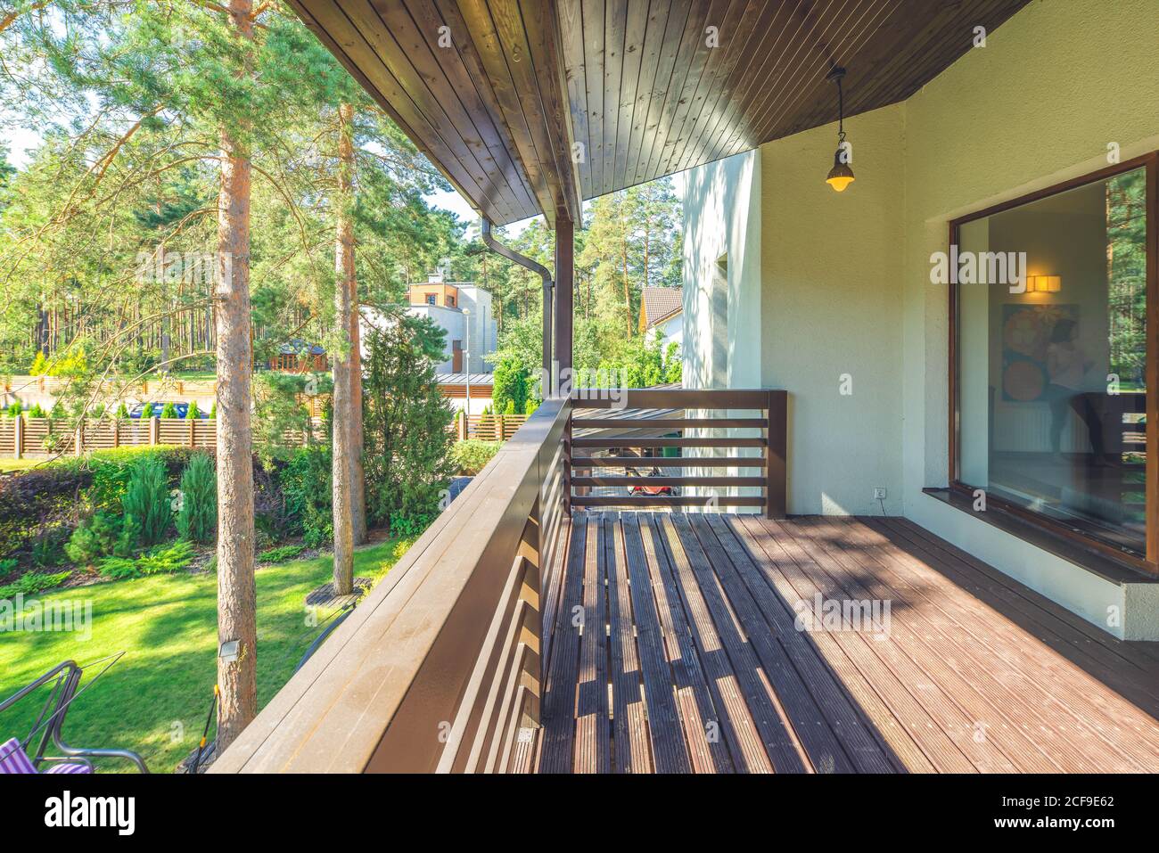 Modern wooden terrace in luxury cottage. Panorama window. Green garden ...