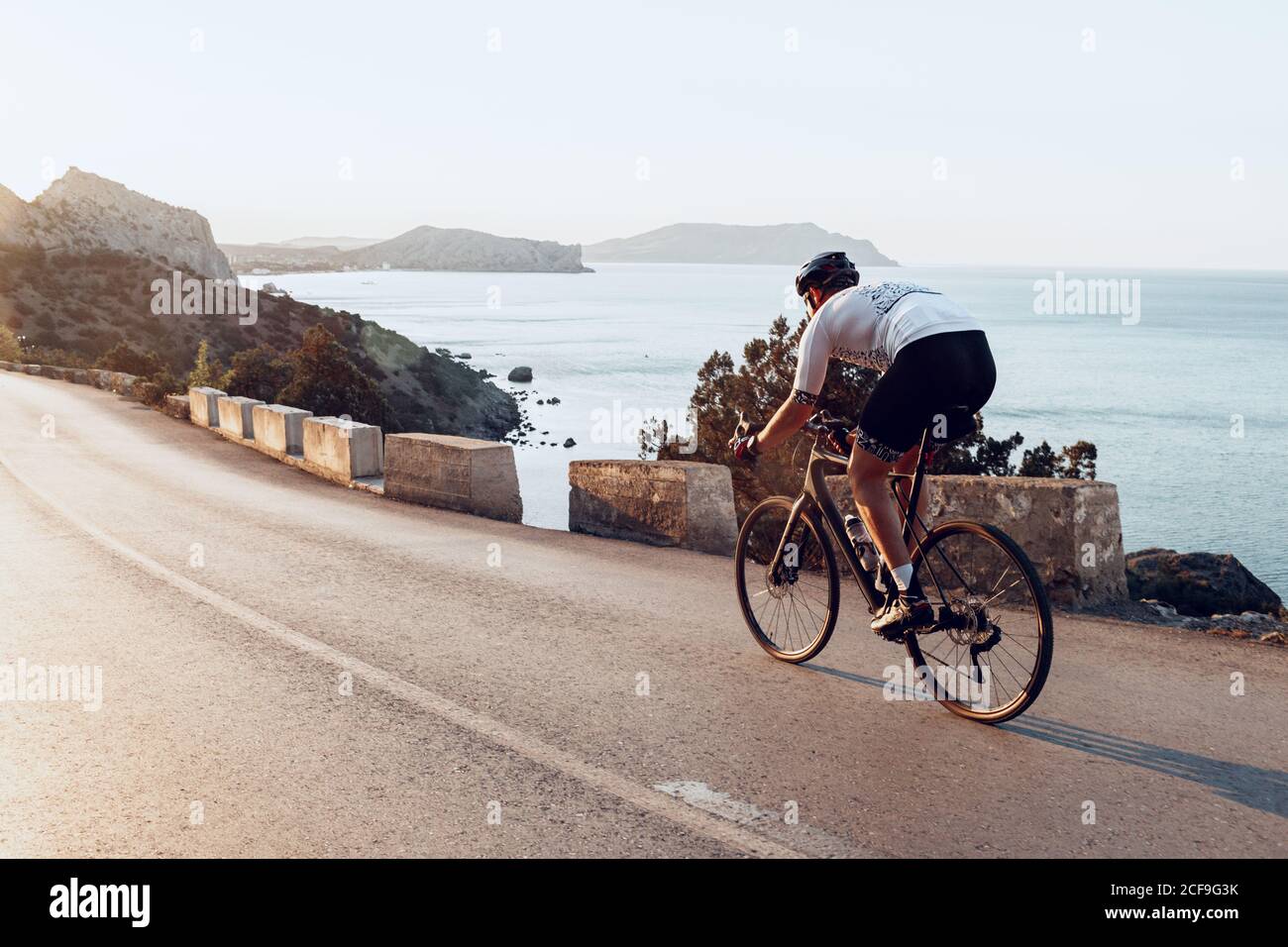 Man cyclist pedaling on a road bike outdoors in sun set Stock Photo - Alamy