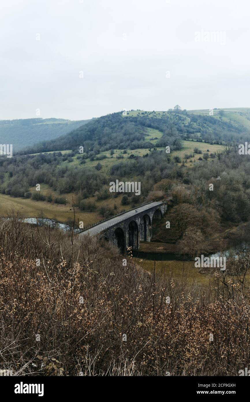 Amazing landscape of hilly valley and stone architectural bridge above ...
