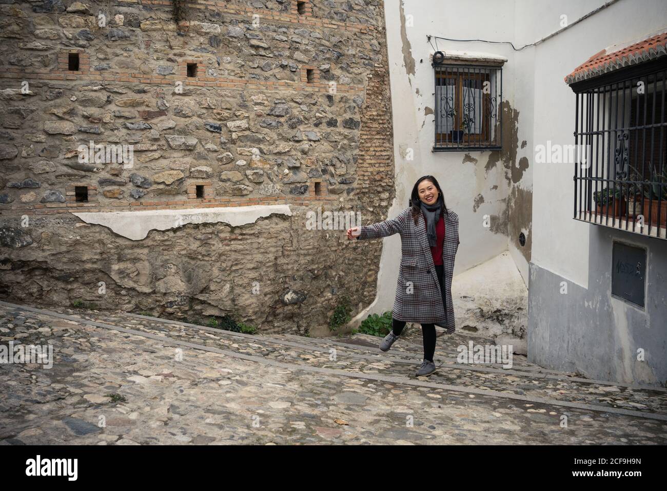 Asian female on aged cobblestone steps in city alley Stock Photo - Alamy