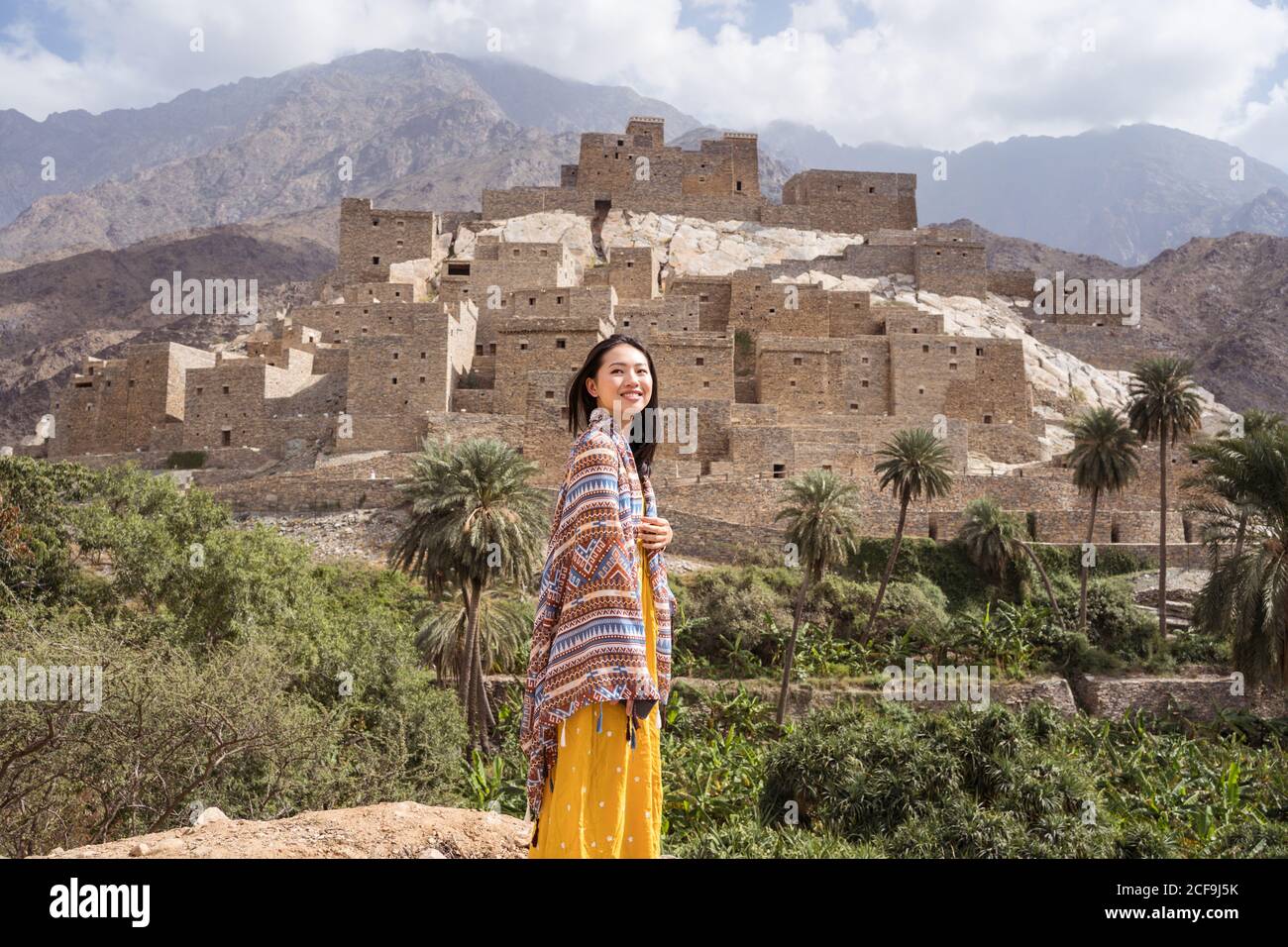 Side view of full body happy ethnic lady in decorative mantle with ...