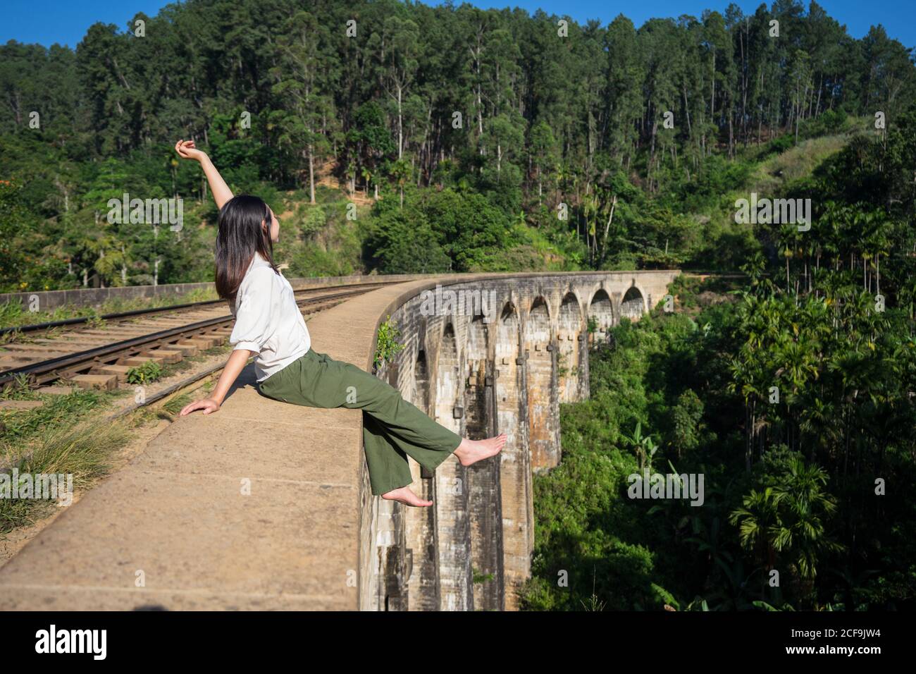 Side view of active pleasant Asian touristic Woman sitting on ancient ...