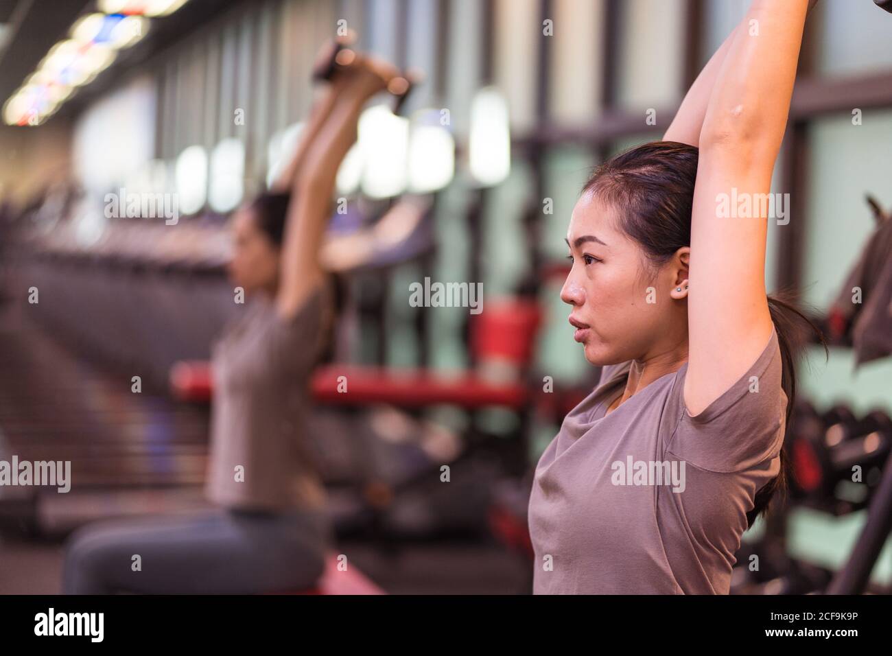 Side view of powerful ethnic female athlete in sportswear doing ...