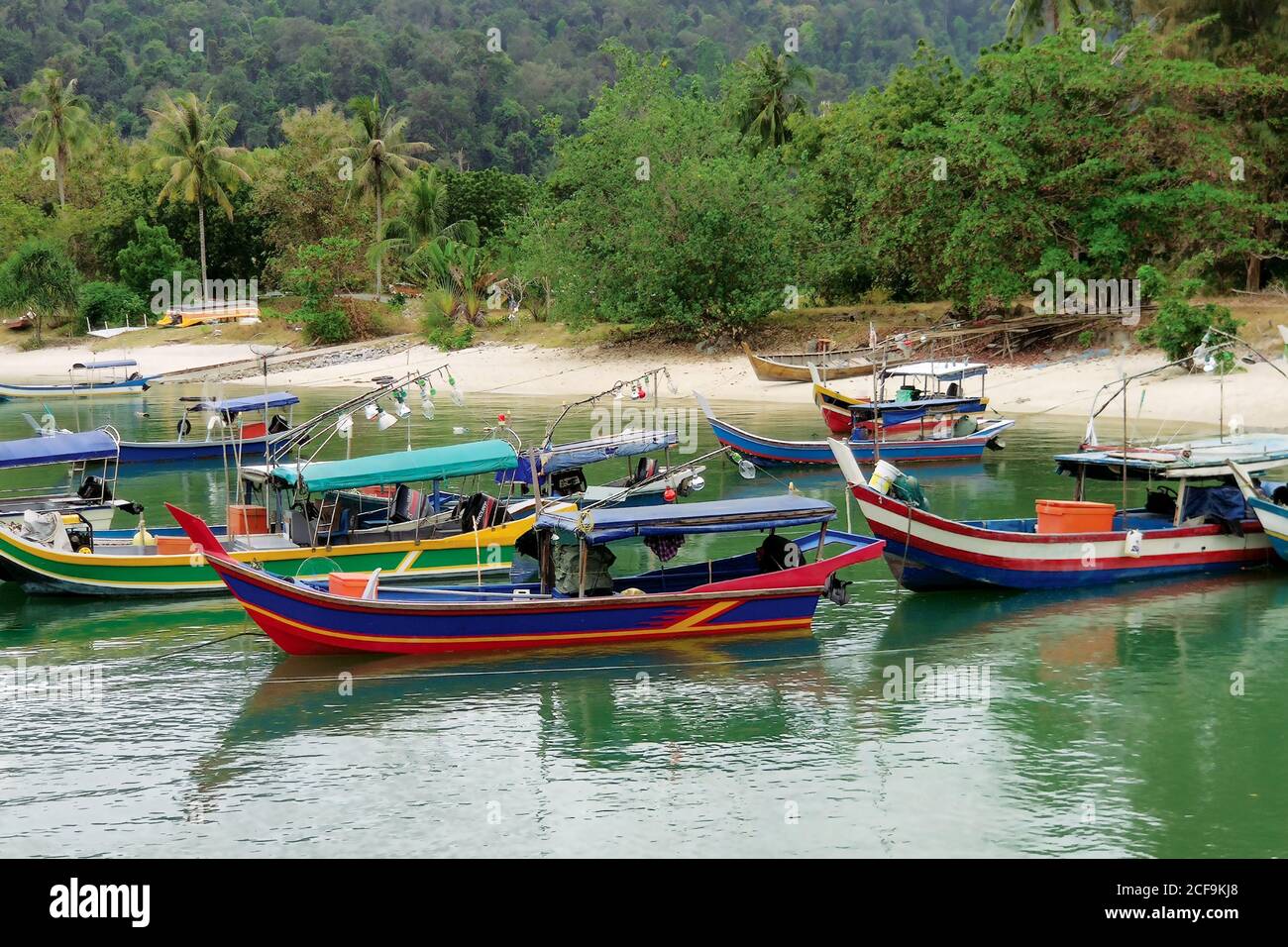 Colourful boats docked around tropical beach Stock Photo - Alamy