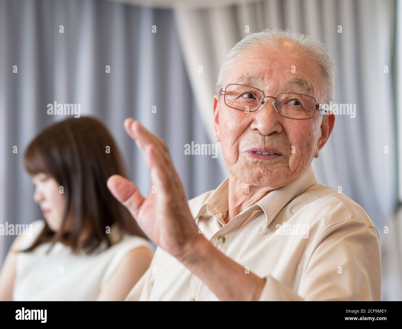 An old man talking animatedly at a family event Stock Photo - Alamy