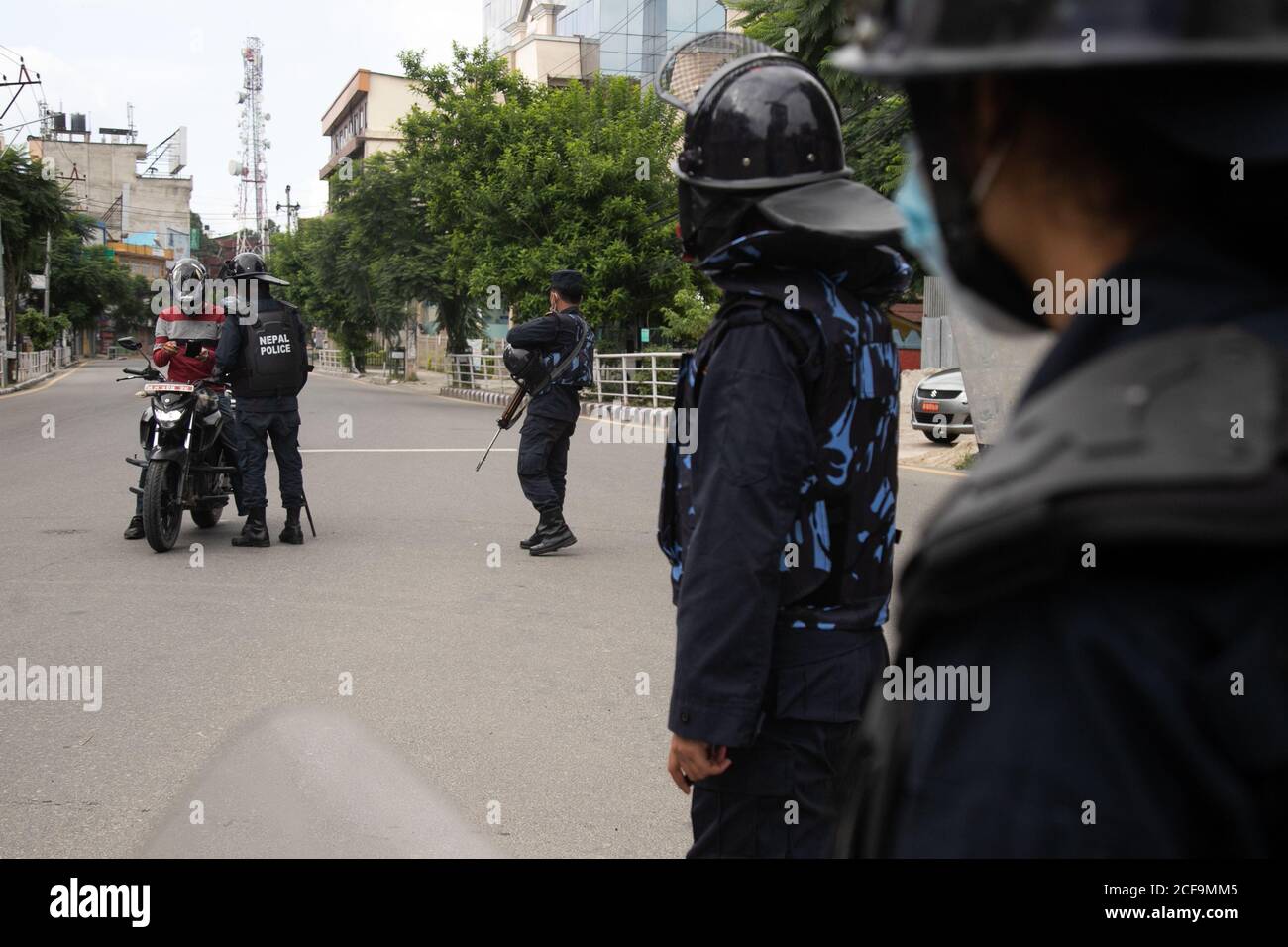 Lalitpur, Nepal. 04th Sep, 2020. Riot policemen inspect a motorcyclist ...