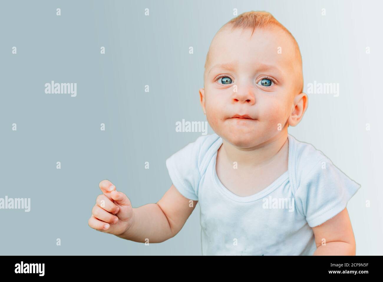 Beautiful one year old baby boy with blue eyes isolated on blue ...