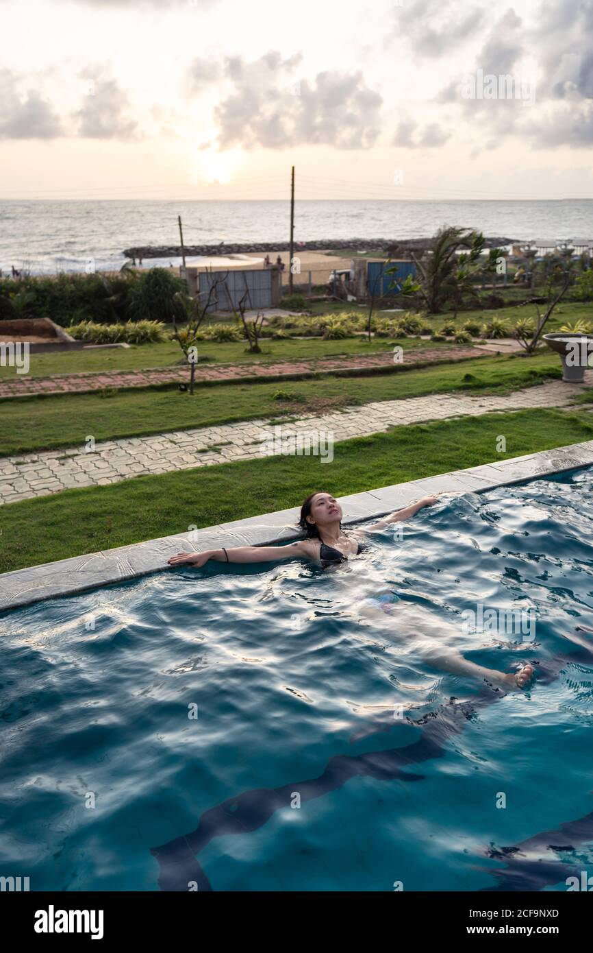 Female traveler in swimsuit resting in pool at resort Stock Photo - Alamy
