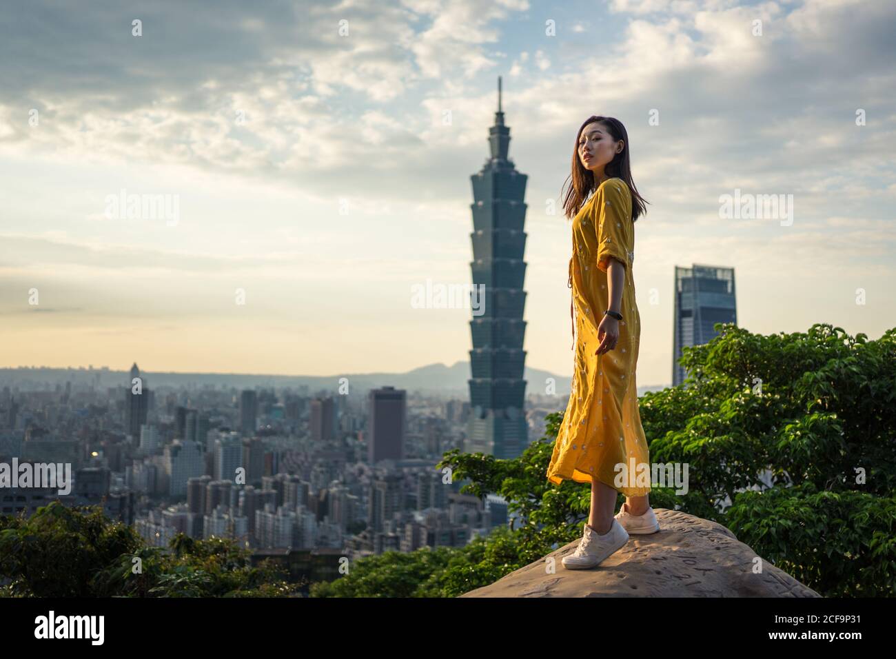 Young resting lady delighting in views in rock at big city Stock Photo ...