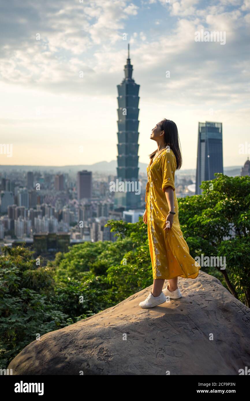 Young resting lady delighting in views in rock at big city Stock Photo ...