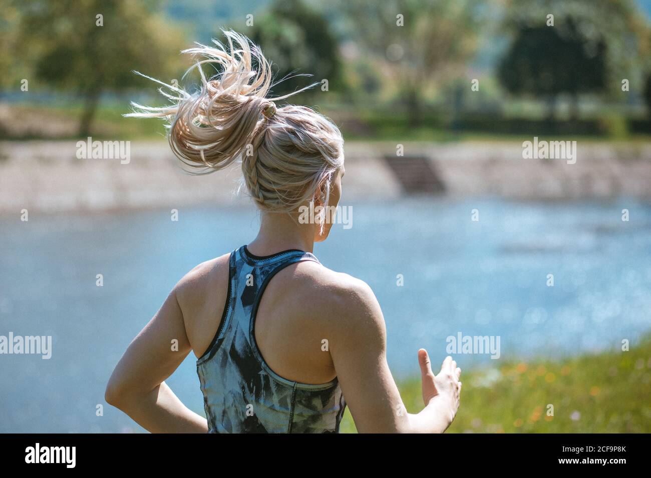 Back view photo of young blonde girl running in the nature, by the ...