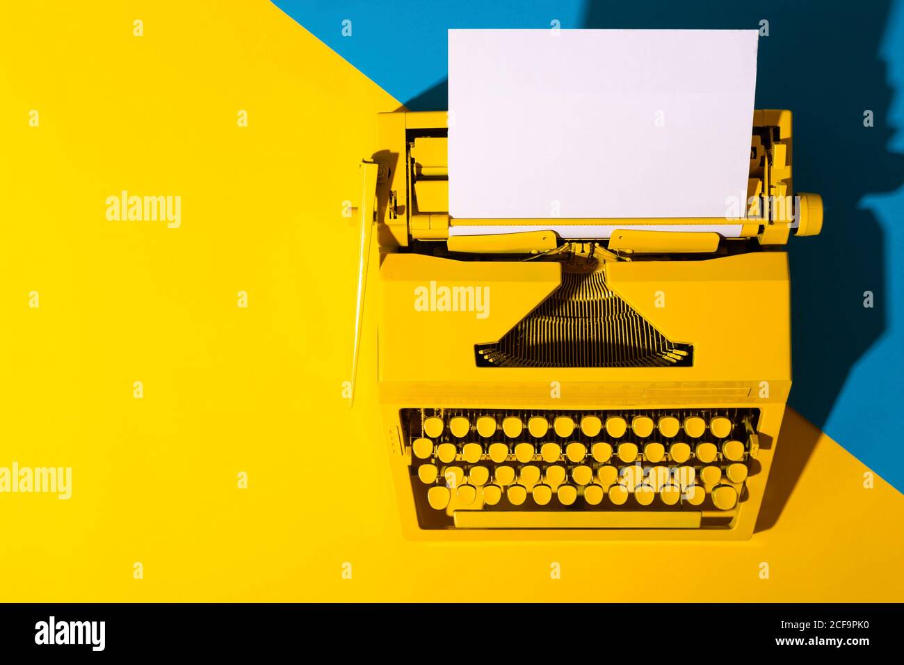 Yellow bright typewriter on a yellow and blue background. Creativity ...