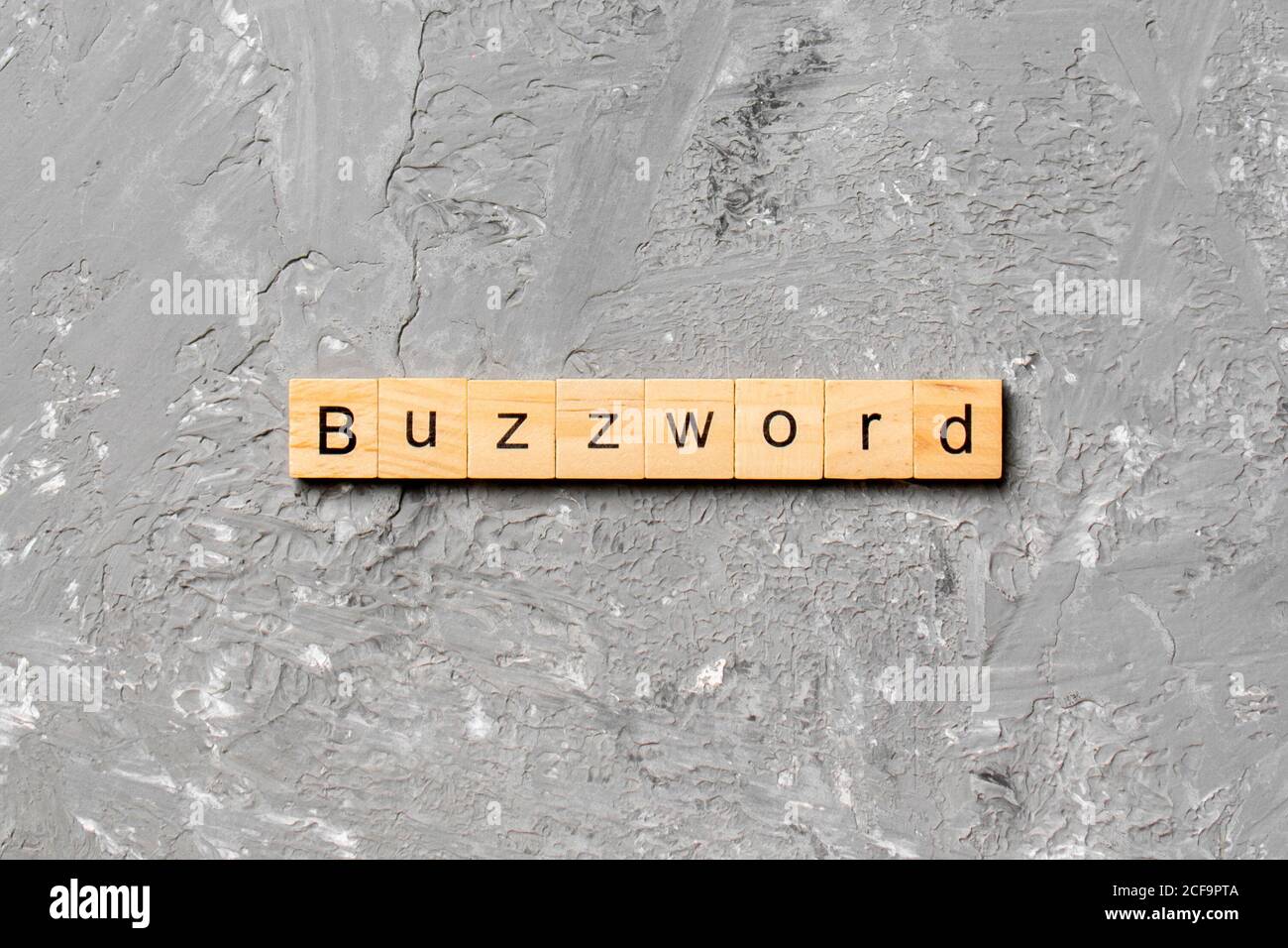 BUZZWORD word written on wood block. BUZZWORD text on cement table for ...
