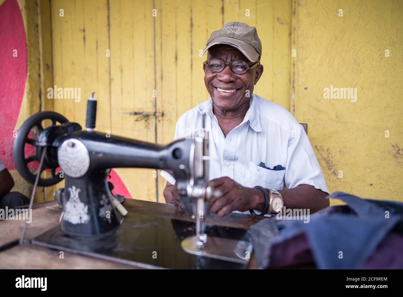 Happy black man using sewing hi-res stock photography and images - Alamy