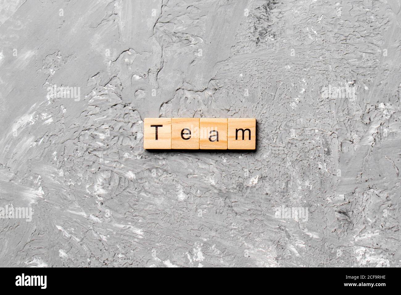 team word written on wood block. team text on cement table for your ...