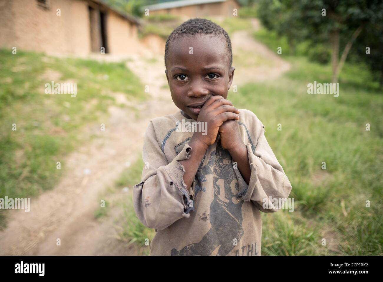 Uganda - November, 26 2016: Bald African kid biting snack and looking ...